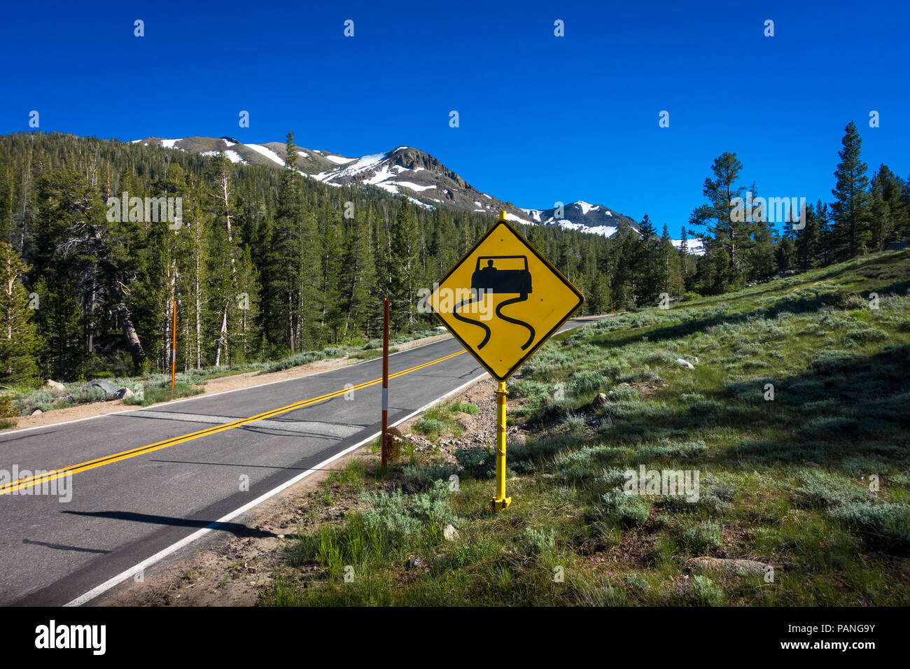 Yellow "slippery road" sign with snowy forest peaks - Highway 108 ...