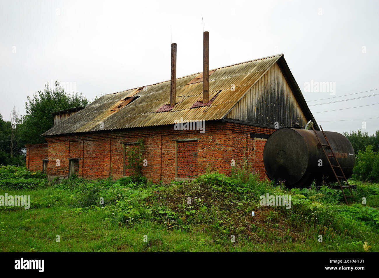 Brick farm house and metal tank Stock Photo - Alamy