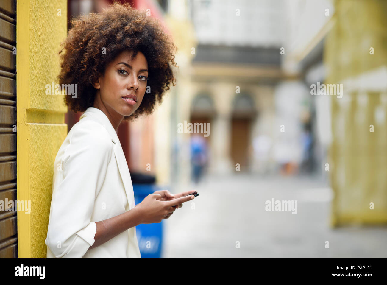 Portrait of waiting young woman with cell phone Stock Photo - Alamy