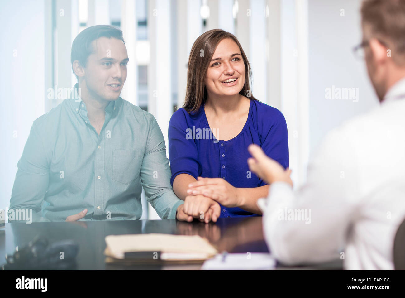 Doctor talking to couple in medical practice Stock Photo - Alamy
