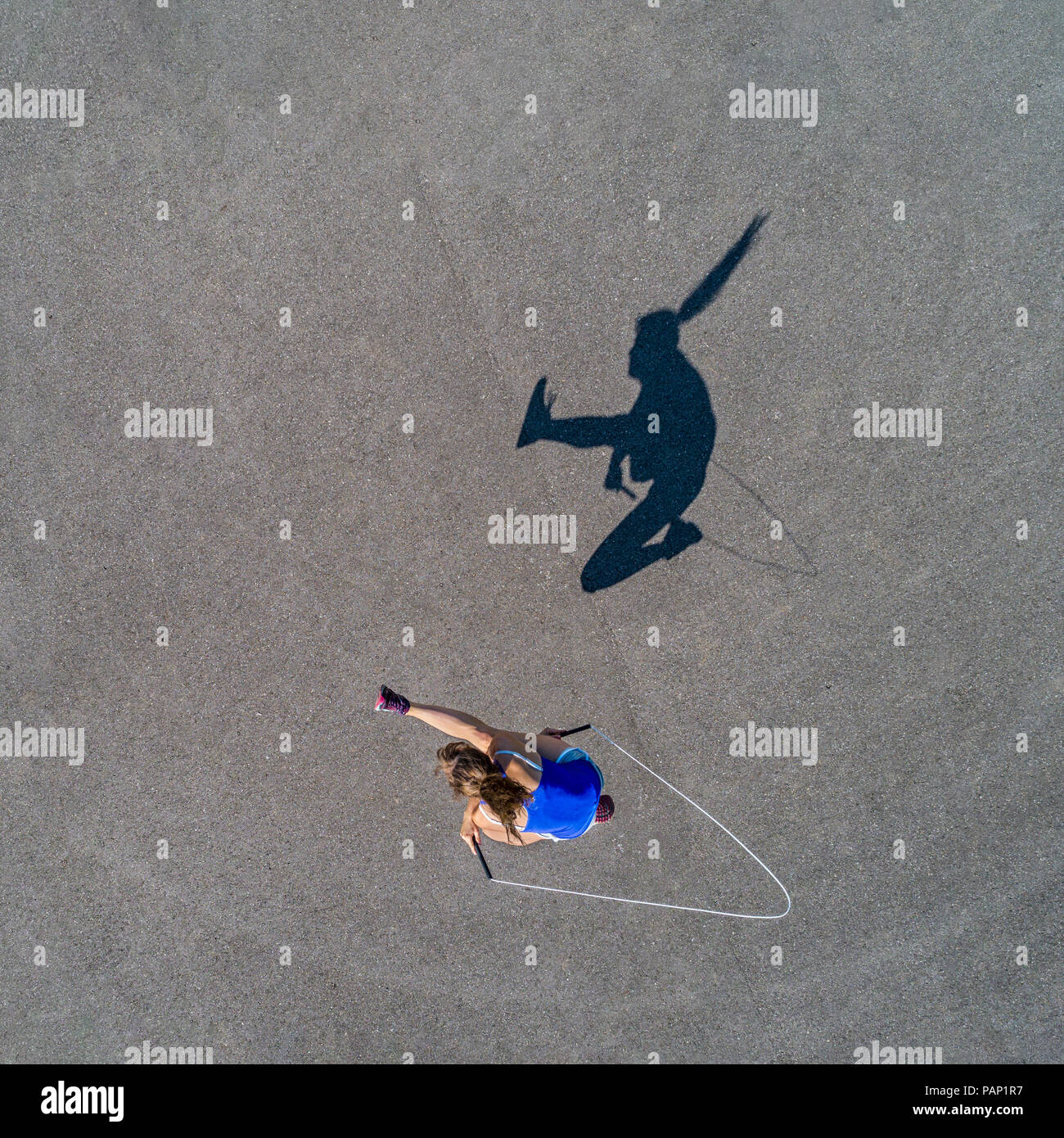 Aerial view of young woman skipping rope, shadow Stock Photo - Alamy