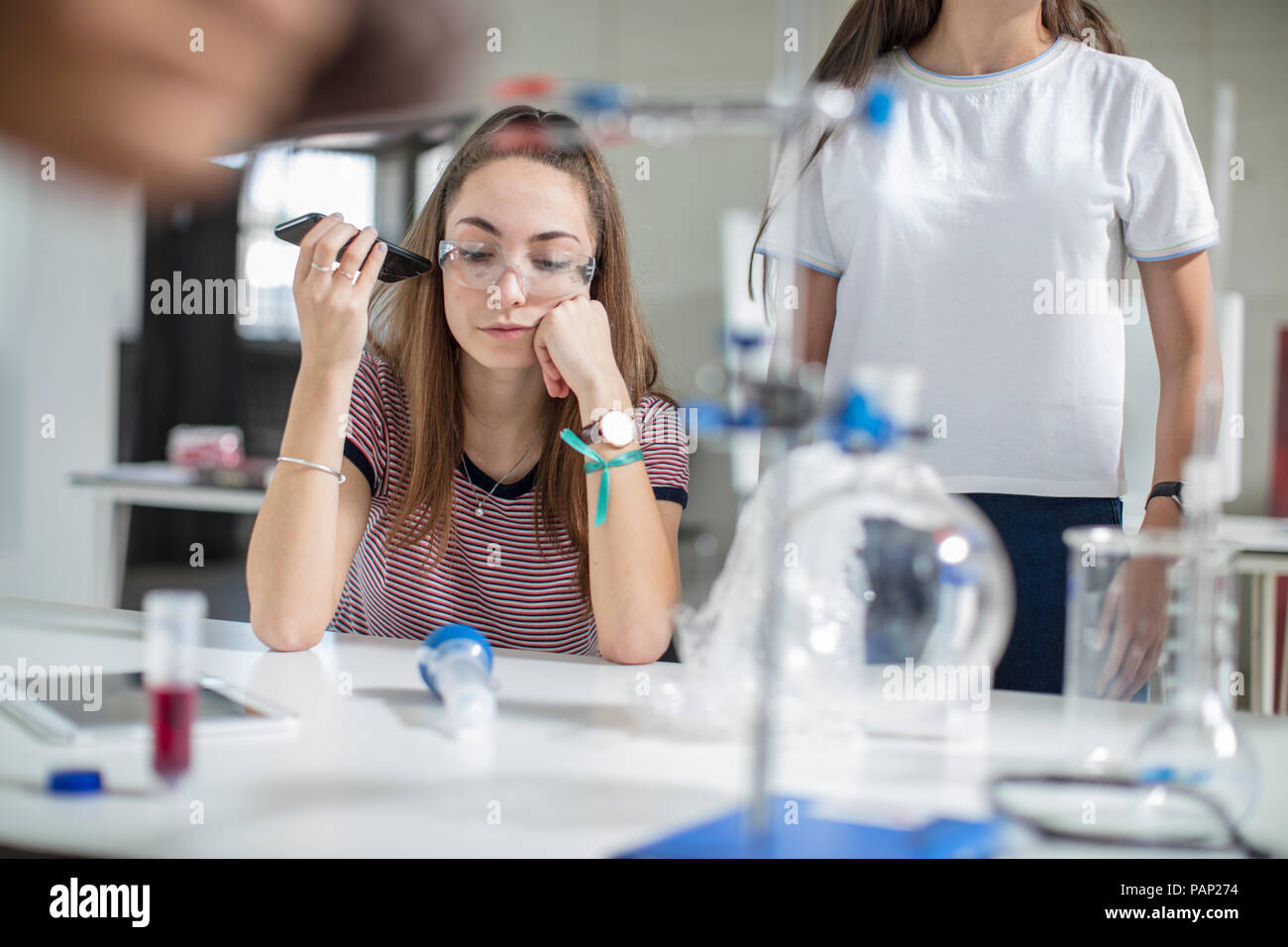 Teenage girl with cell phone in science class Stock Photo - Alamy