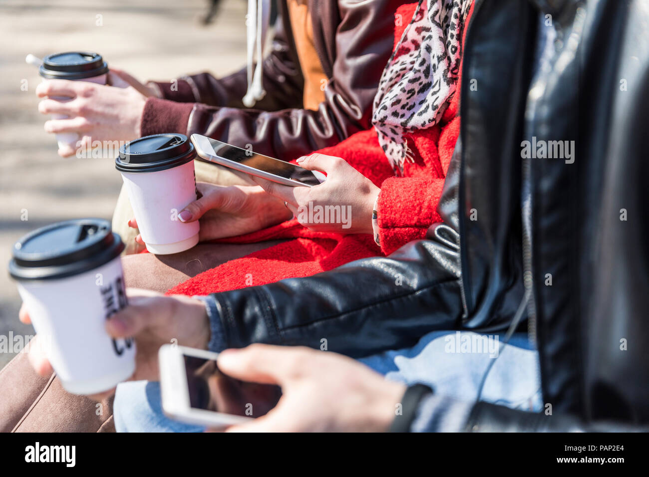 Russia, Moscow, details of three friends holding smartphones and coffee ...