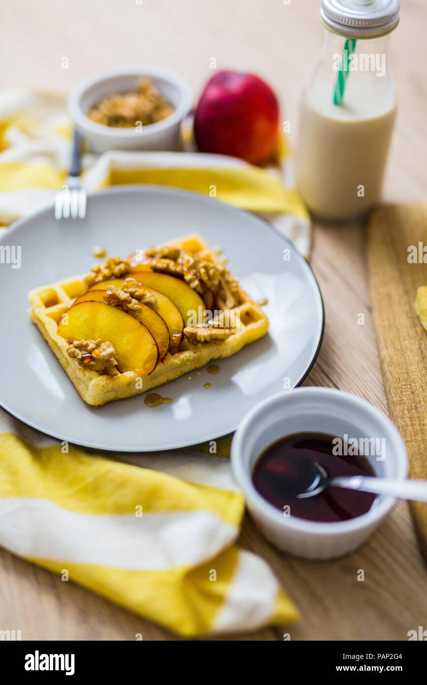 Waffle garnished with nectarine, walnuts and maple sirup Stock Photo ...
