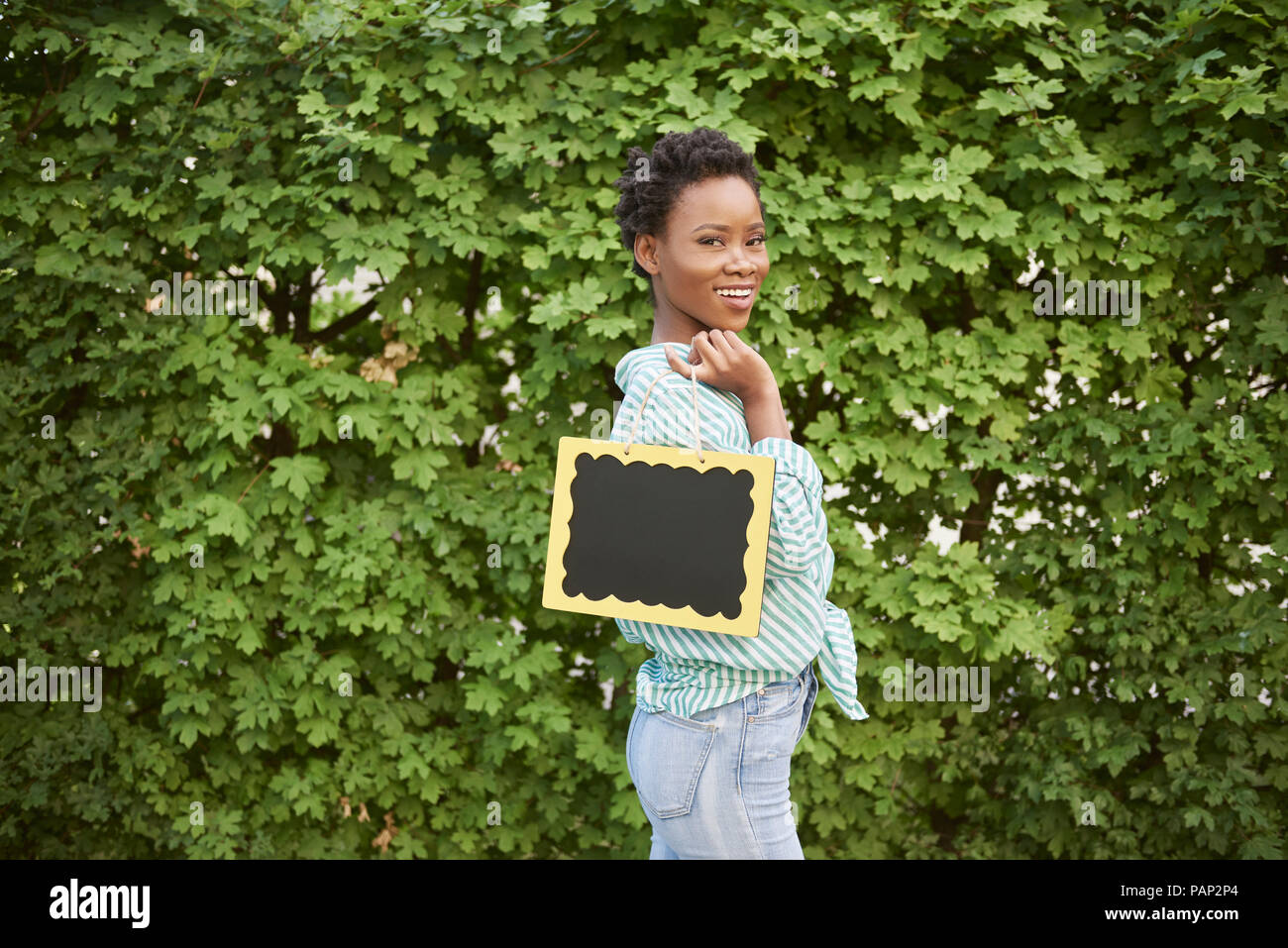Portrait of smiling young woman with chalkboard Stock Photo - Alamy