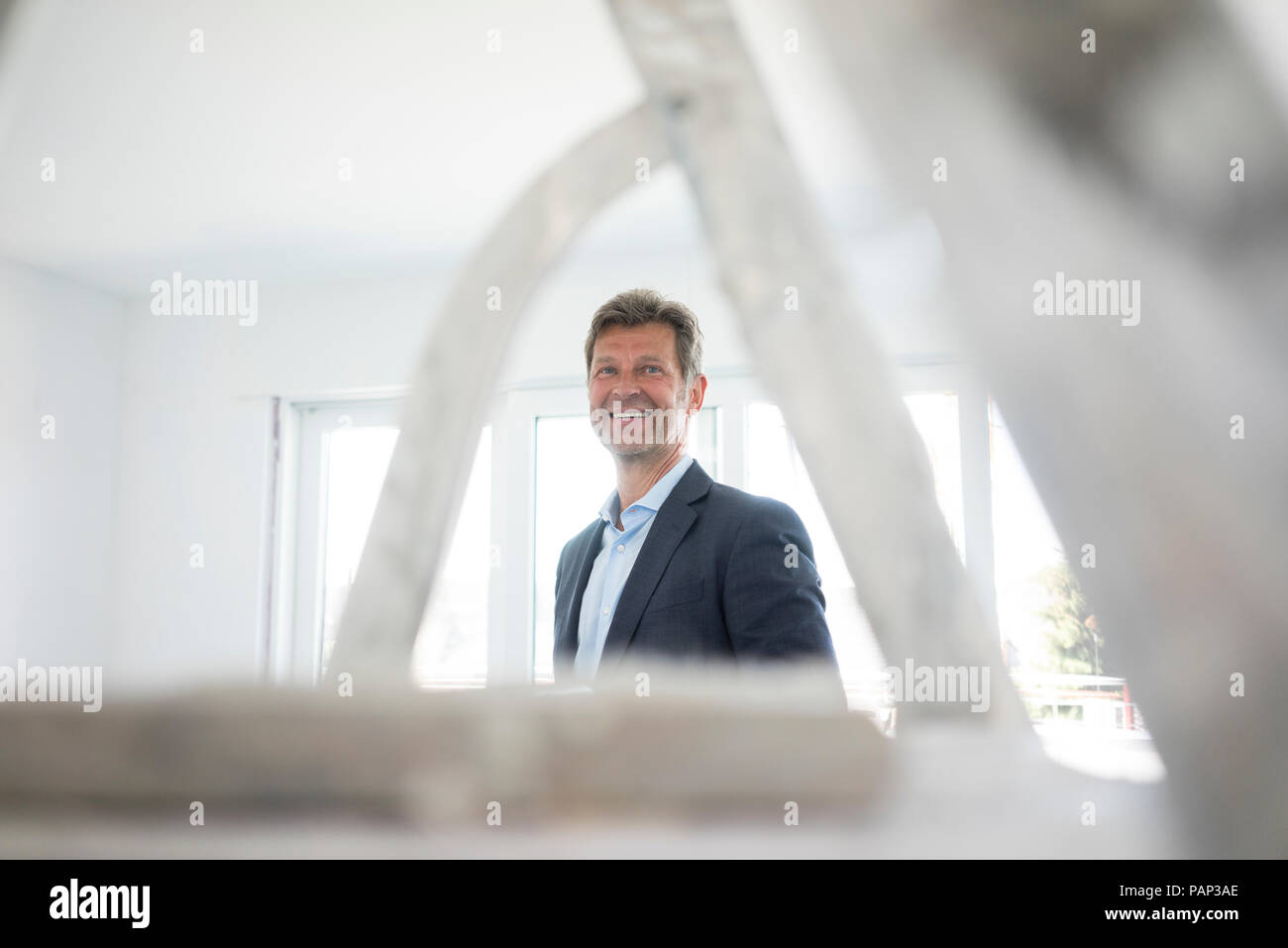 Portrait of smiling man in suit in building under construction Stock ...