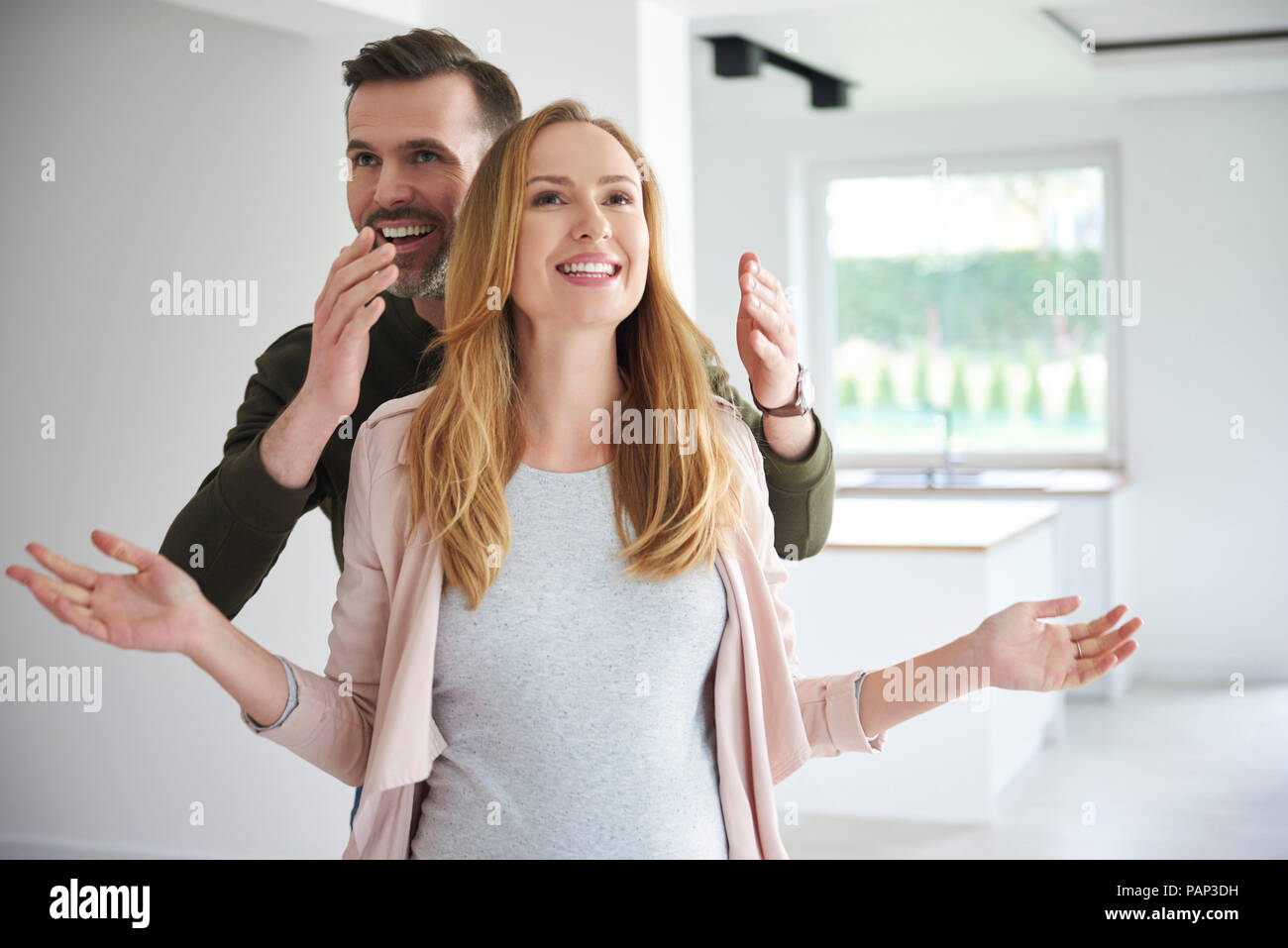 Man surprising woman in empty flat Stock Photo - Alamy