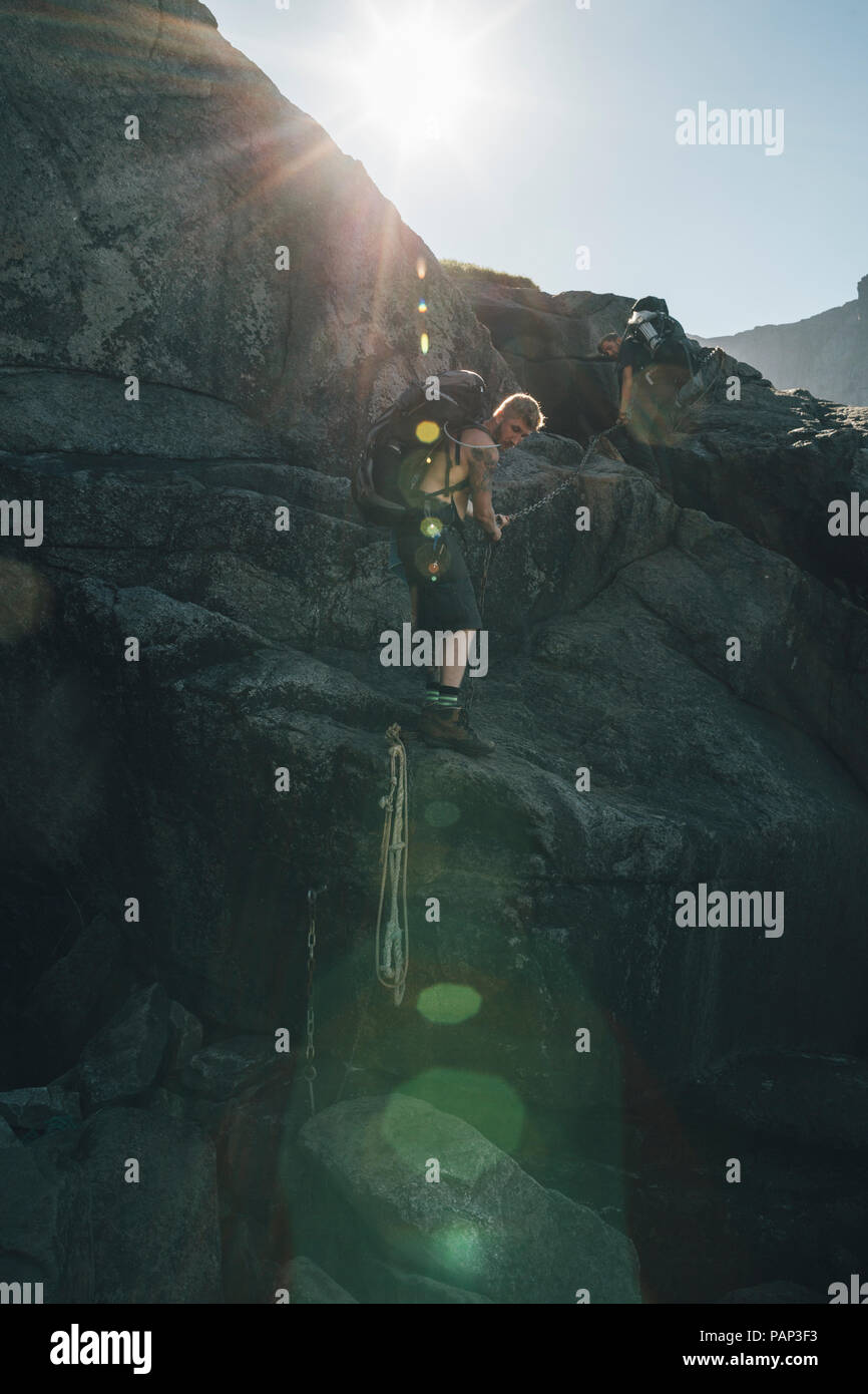 Norway, Lofoten, Moskenesoy, Young men men climbing rocks Stock Photo ...