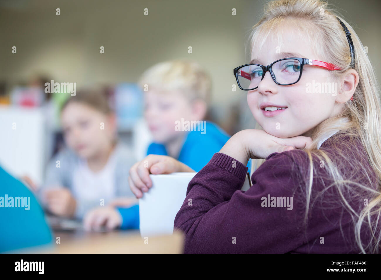 Portrait of smiling schoolgirl with classmates in class Stock Photo - Alamy