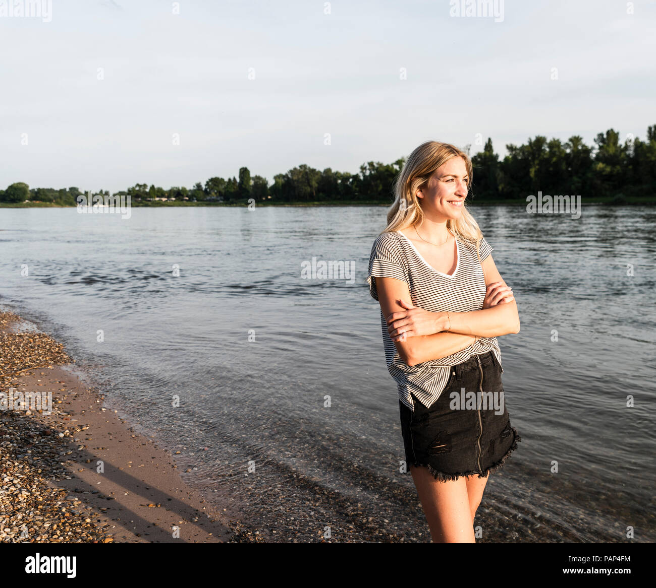 Blond woman at riverside in the evening Stock Photo - Alamy
