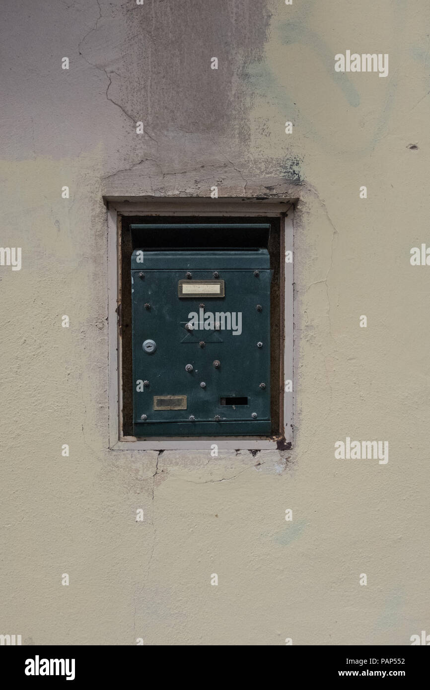 Green mailbox with worn yellow wall in the background Stock Photo - Alamy