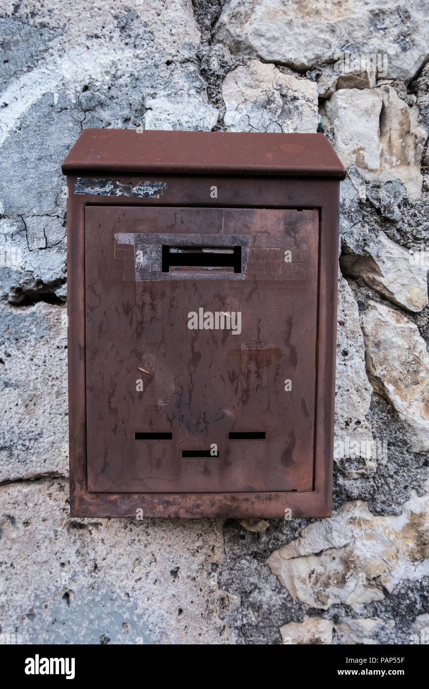 Rusty mailbox with huge stone wall in the background Stock Photo - Alamy