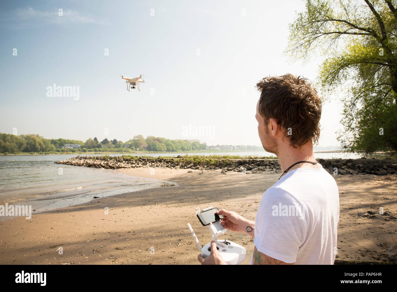 Man flying drone at a river Stock Photo - Alamy