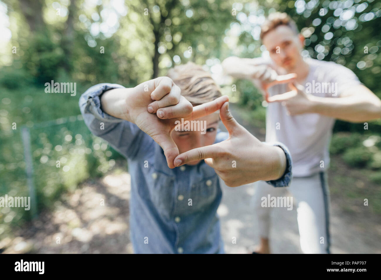 Boy and young man making a finger frame on forest path Stock Photo - Alamy