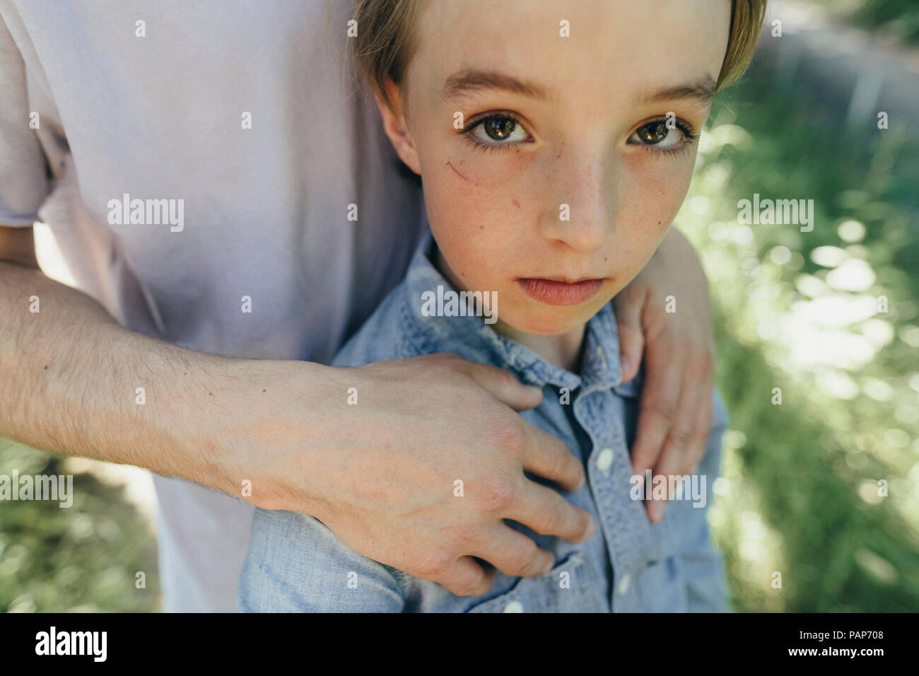 Portrait of boy being embraced by a man Stock Photo - Alamy