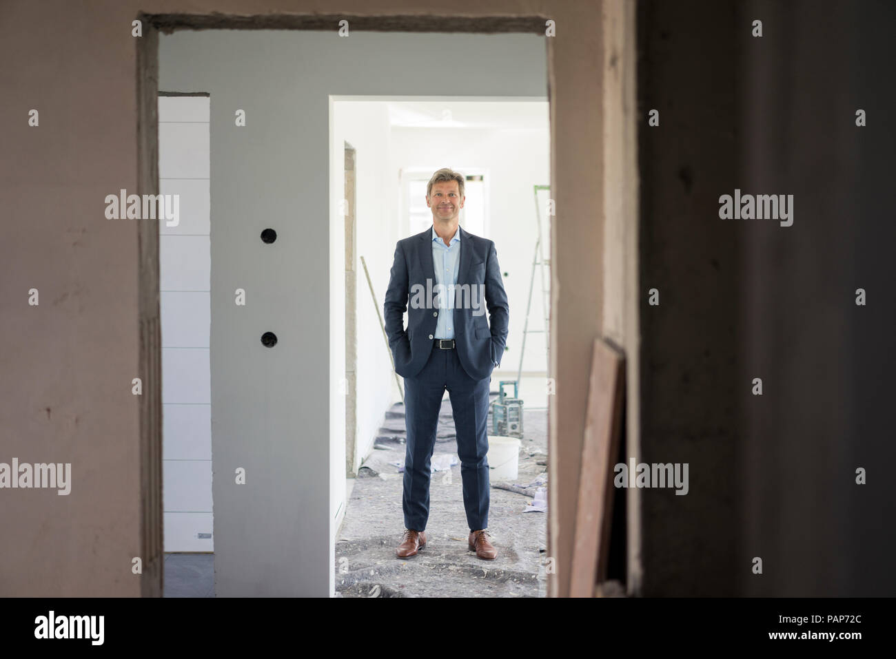 Portrait of smiling man in suit in building under construction Stock ...