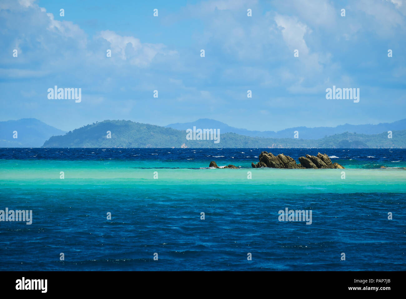 Turquoise water landscape and a sand bar, with rock formations ...