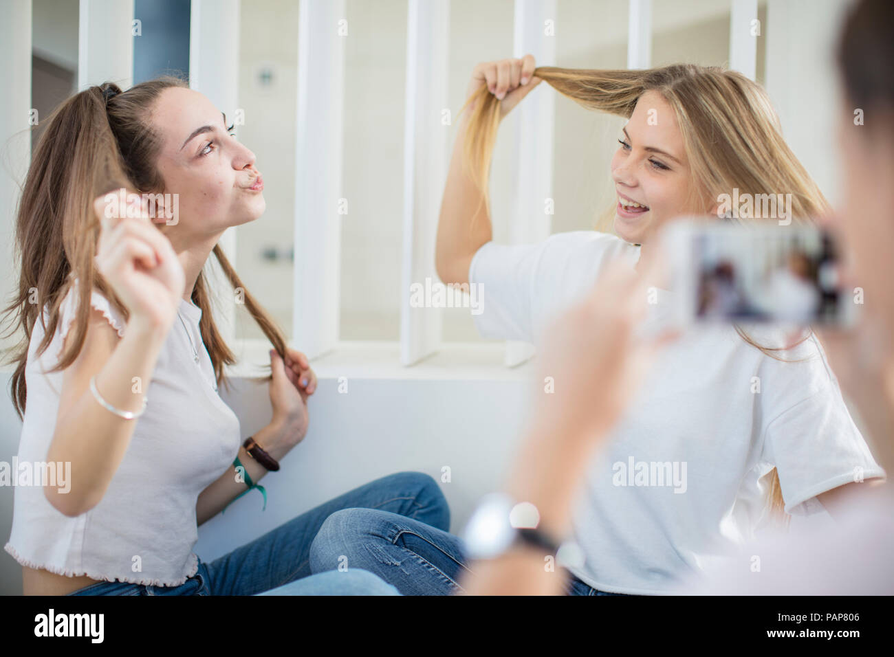 Teenage girl taking cell phone picture of her happy friends Stock Photo ...