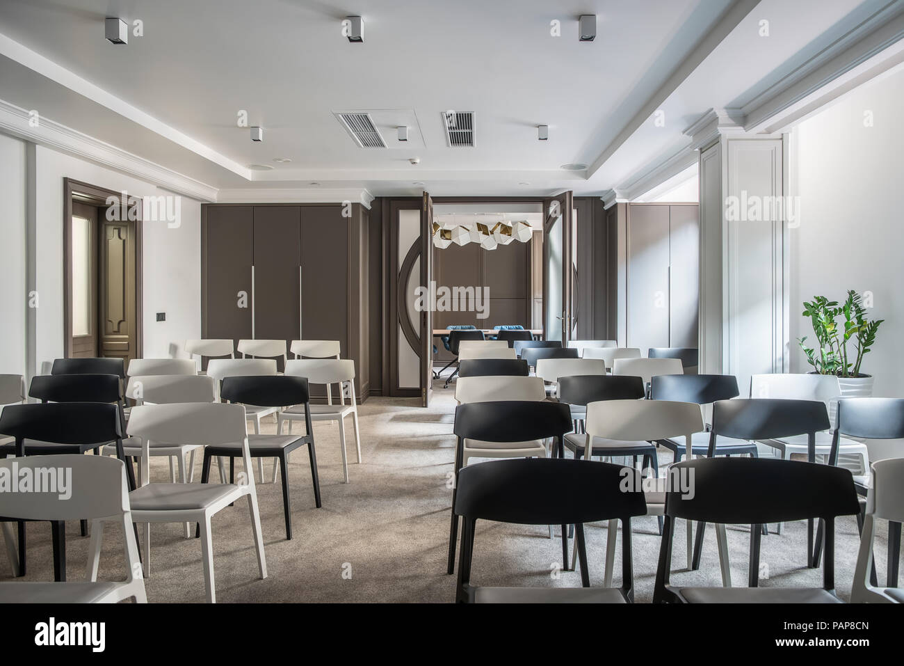 Stylish conference hall with white walls and a gray floor. There are ...
