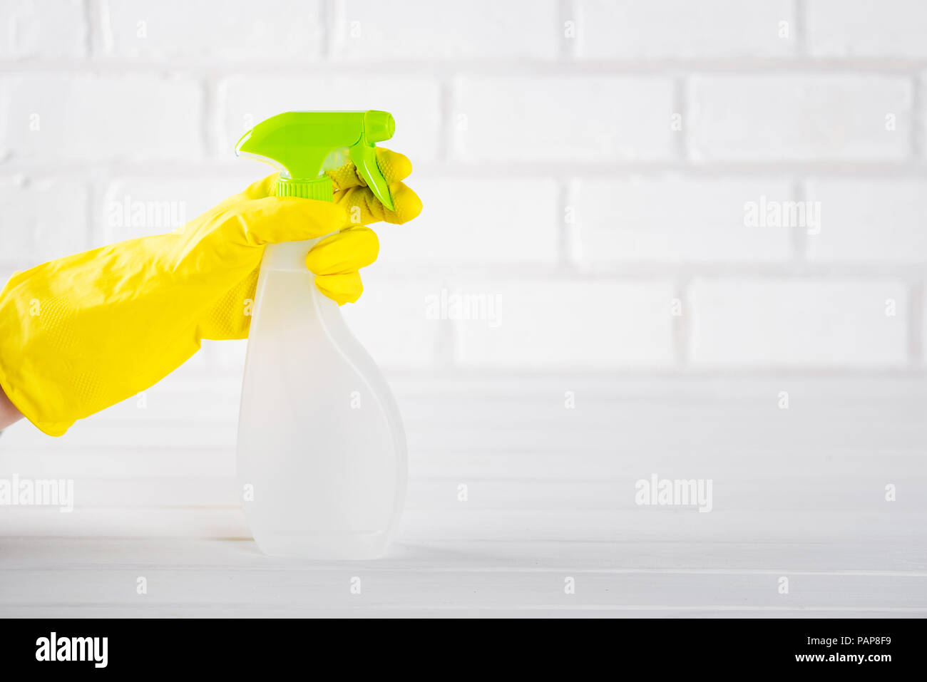 hand holding a house-cleaning spray on an light background. Copy space ...
