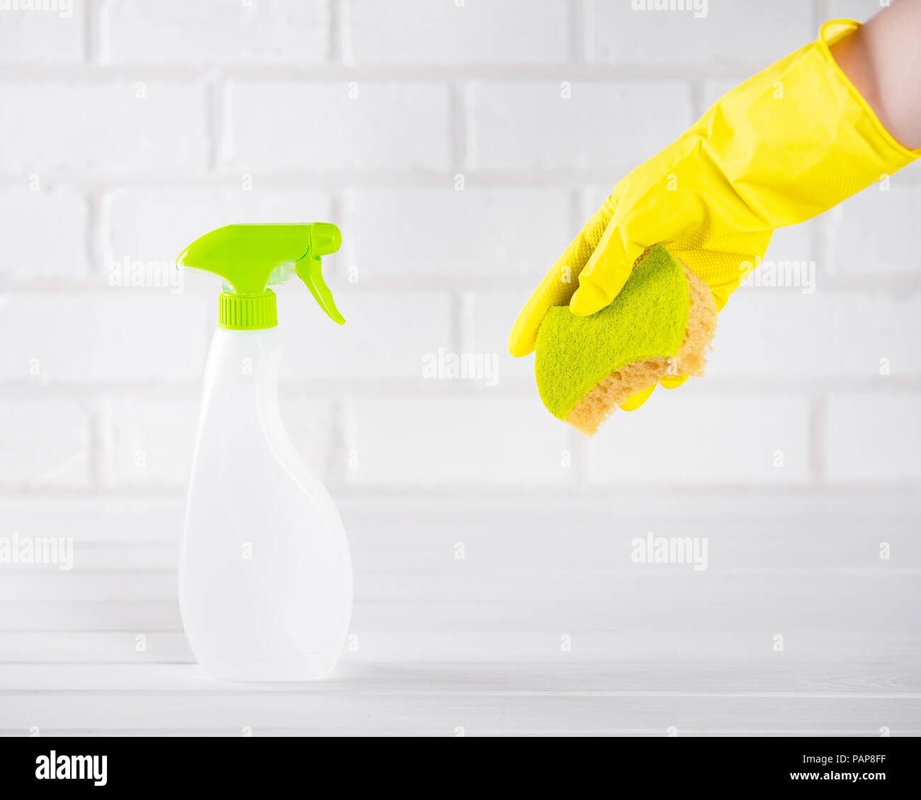 hand holding a house-cleaning spray on an light background. Copy space ...