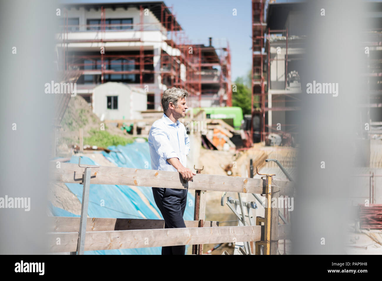 Man on construction site looking around Stock Photo - Alamy