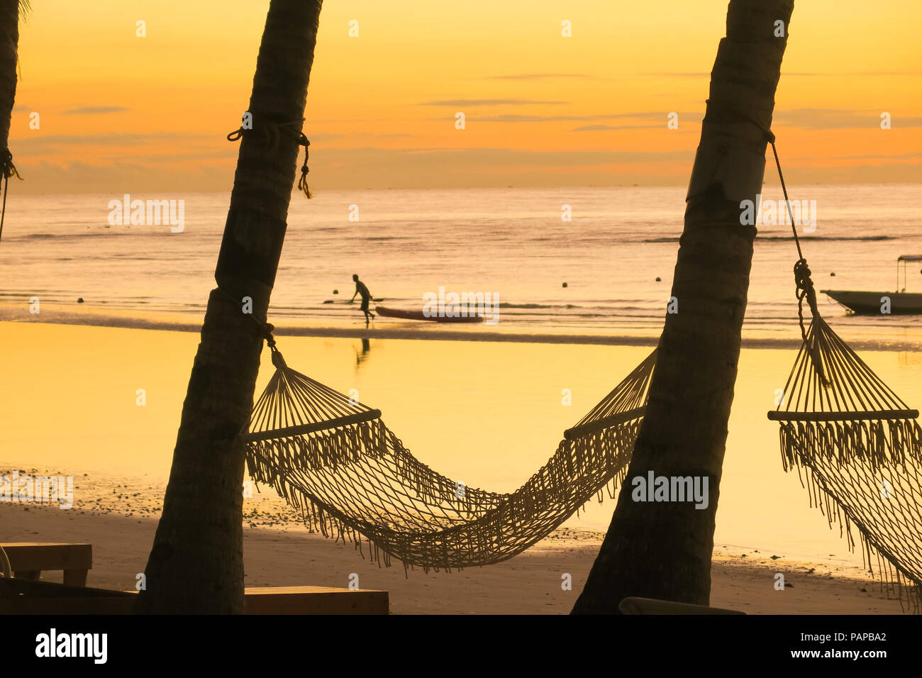 Golden sunset scene with hammocks and kayaker - Panglao, Bohol ...