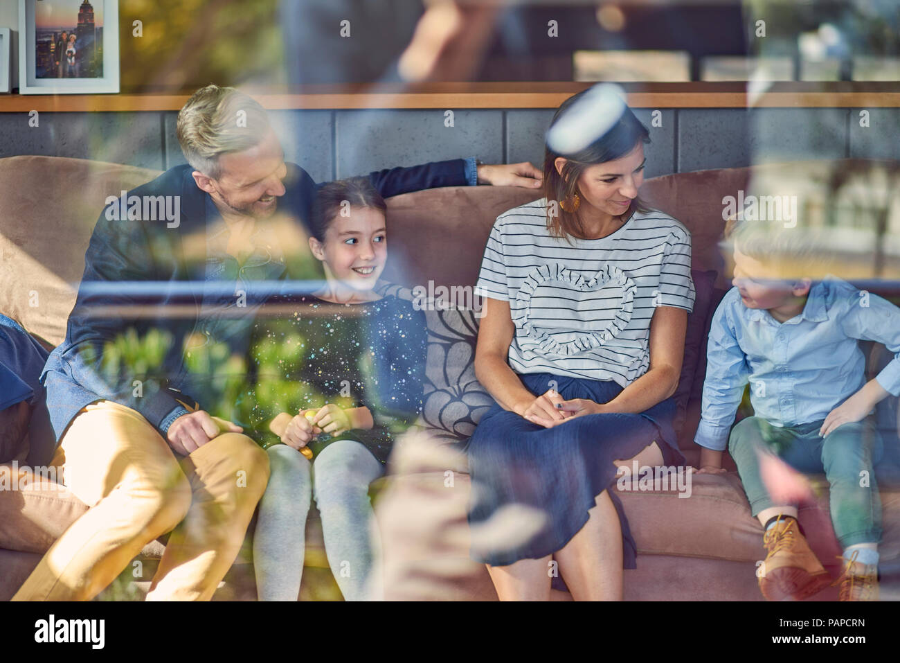 Happy family relaxing on the couch at home Stock Photo - Alamy