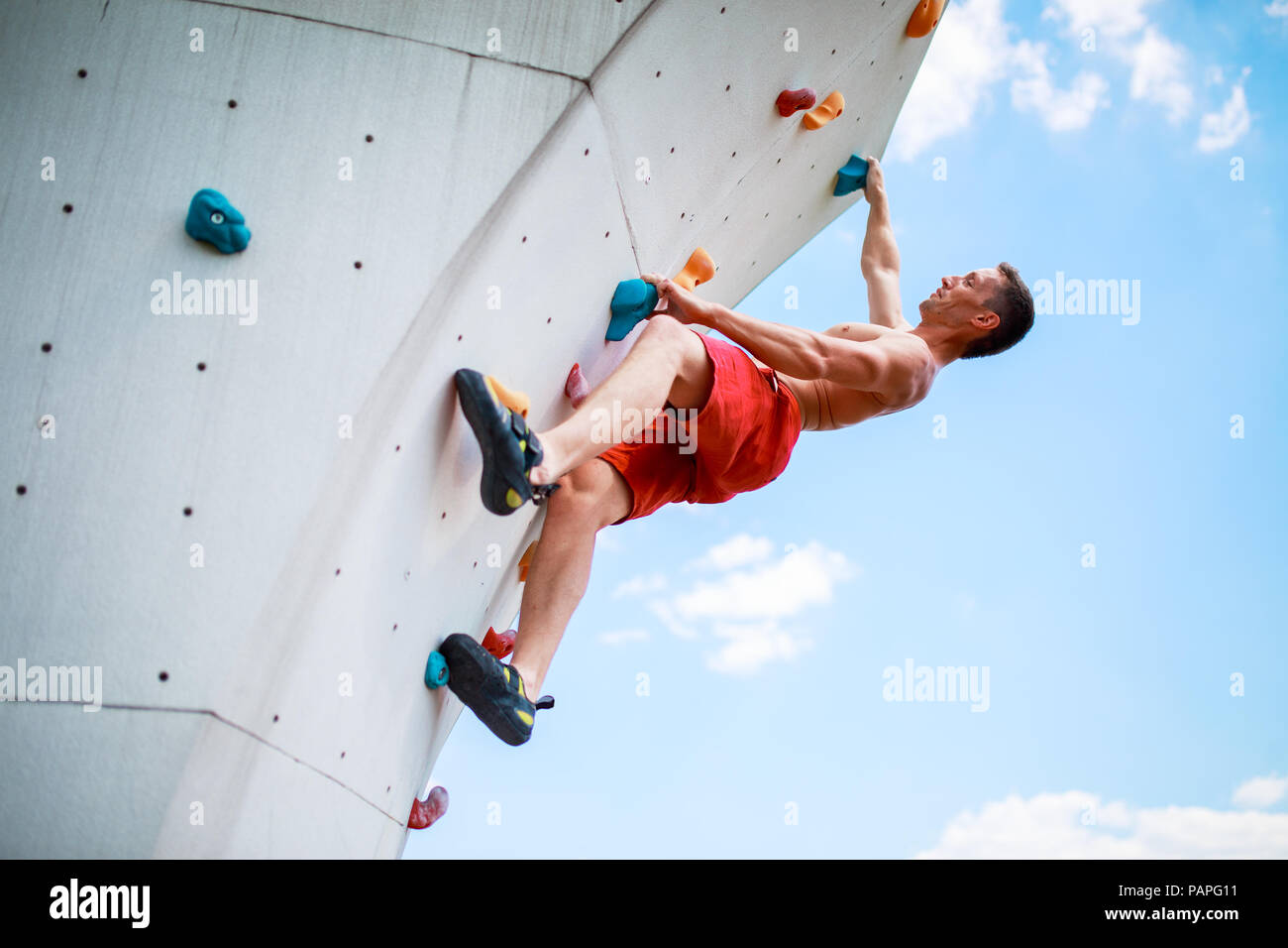 Photo from bottom of strong athletic man exercising on wall for ...
