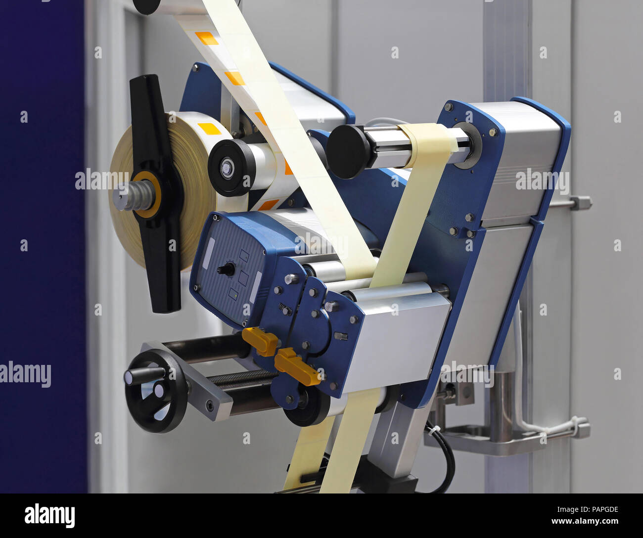 Labelling machine from roll ribbon in factory Stock Photo - Alamy