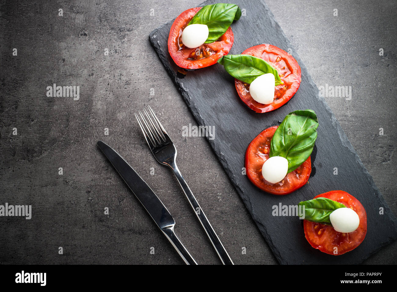 Traditional italian caprese salad on black. Top view Stock Photo - Alamy