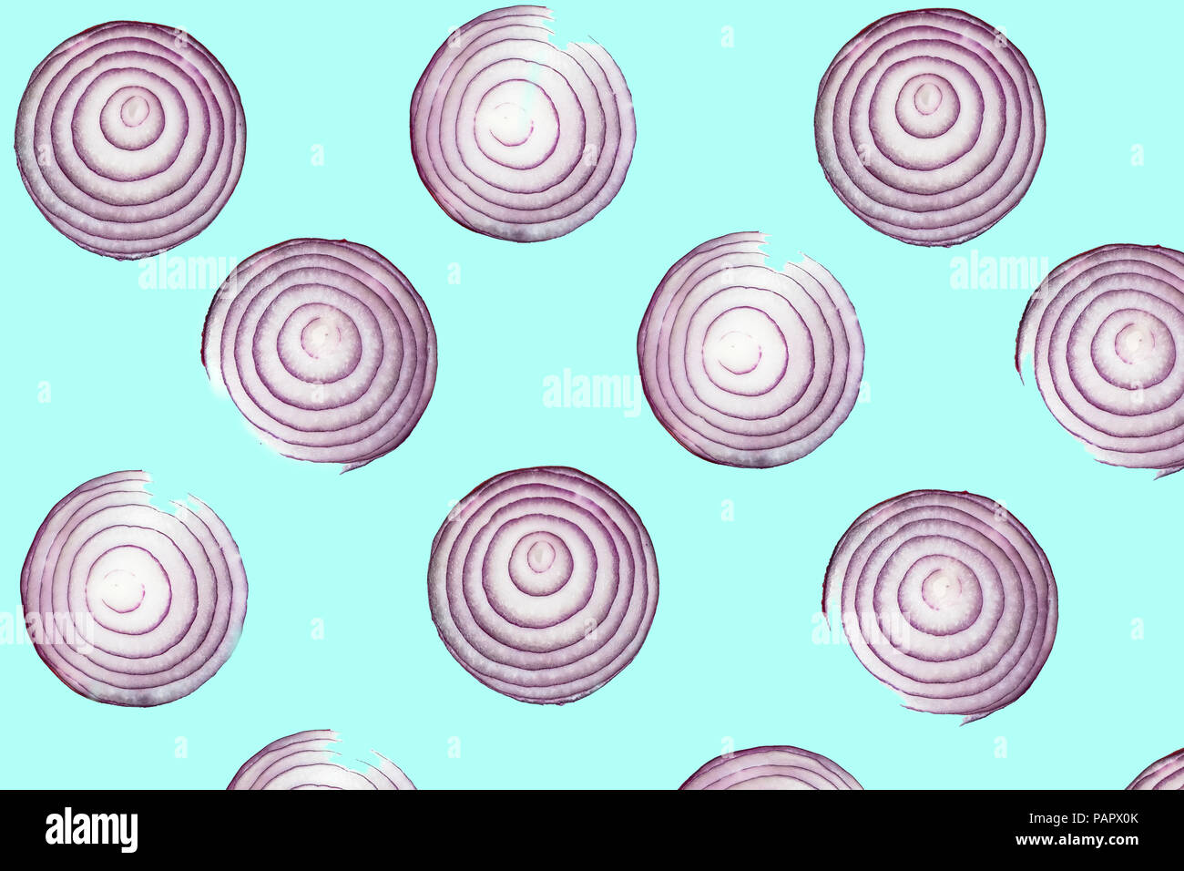 Top view pattern of fresh bright red onion rings on turquoise blue ...