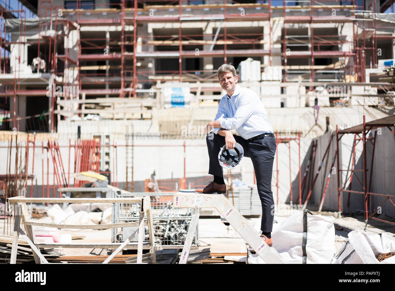Portrait of smiling man standing on construction site Stock Photo - Alamy