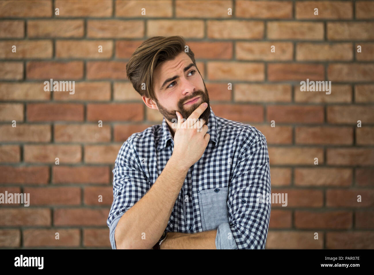 Portrait pensive young man front brick wall hi-res stock photography ...