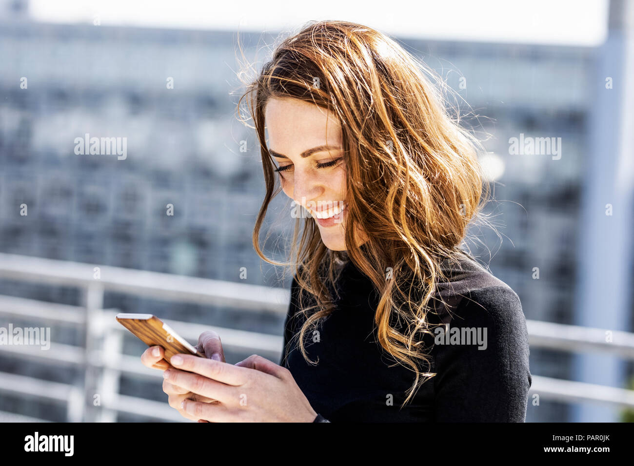 Smiling brunette woman using mobile hi-res stock photography and images ...