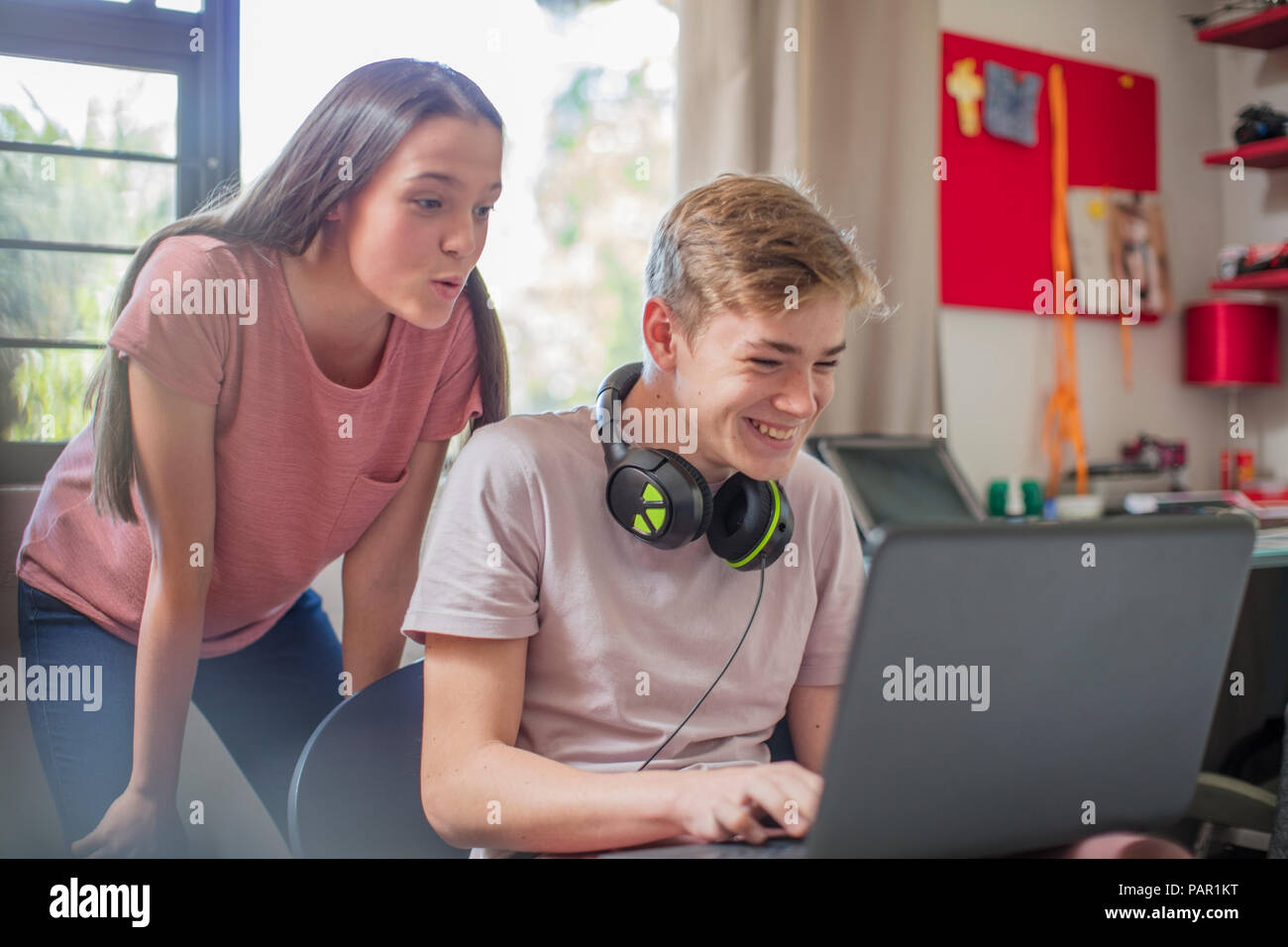 Teenage girl watching boy using laptop Stock Photo - Alamy