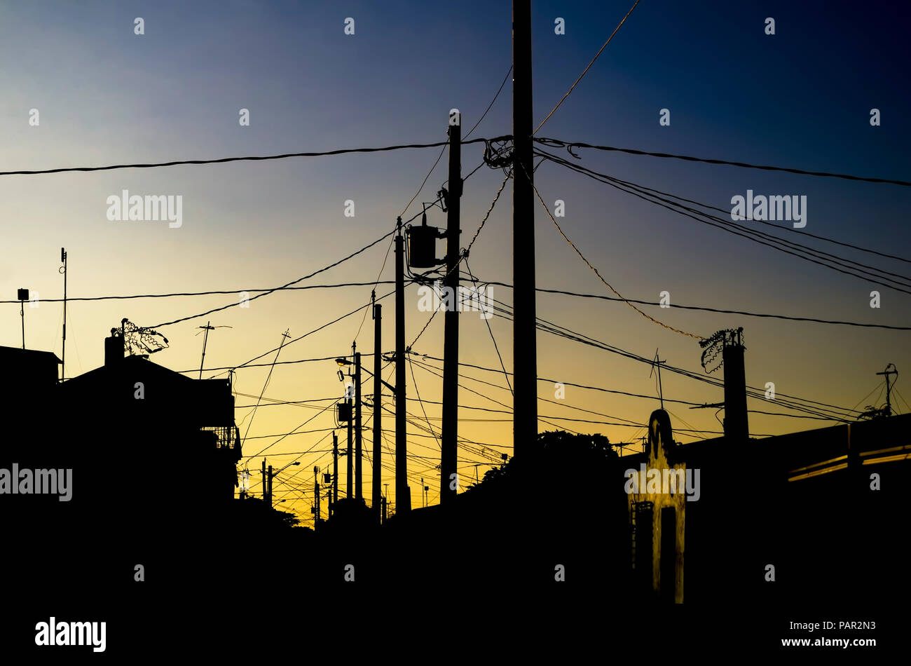 Small houses and electrical wires silhouette during sunset Stock Photo ...