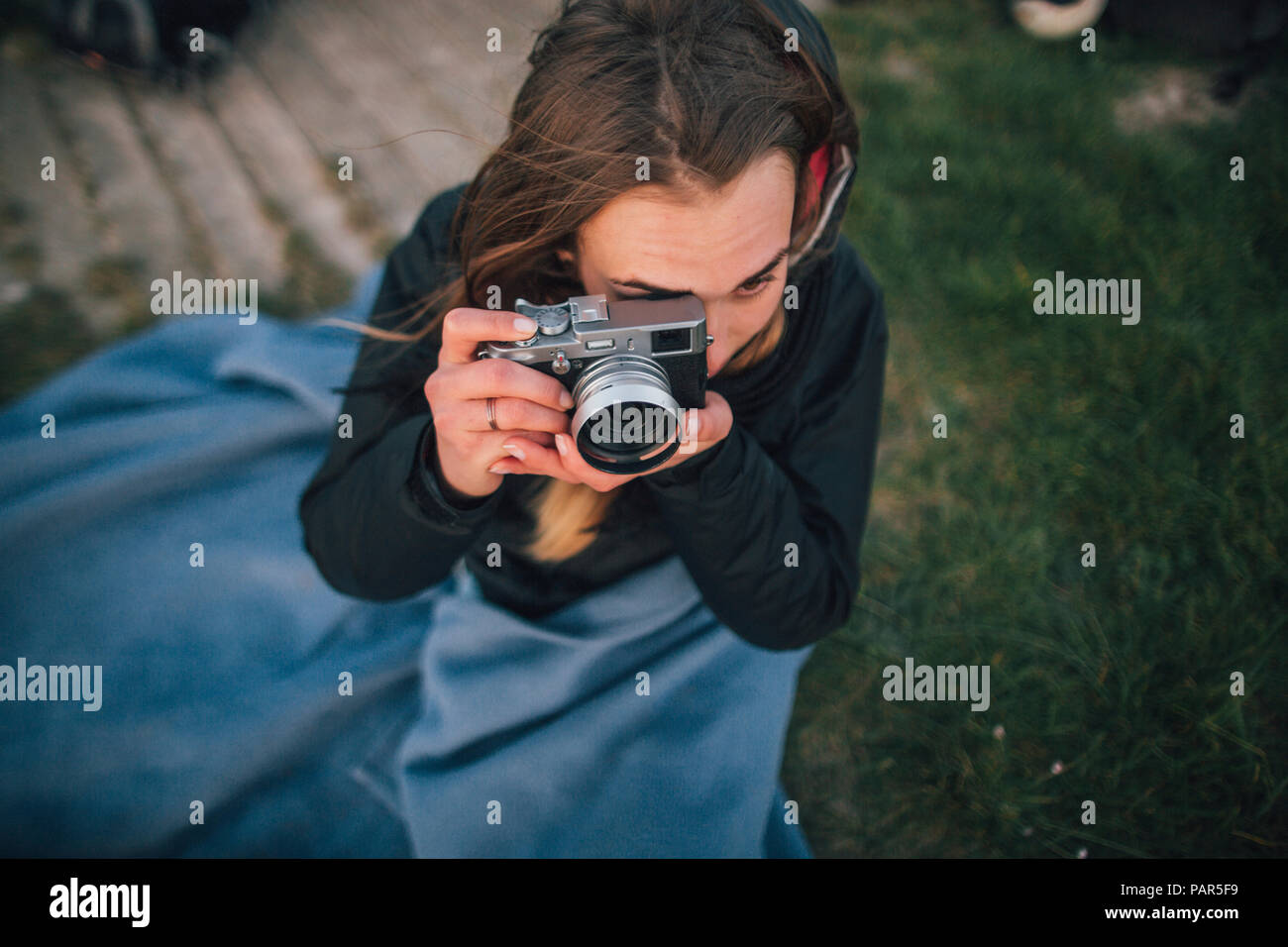 Young woman wrapped in a blanket taking a picture Stock Photo - Alamy