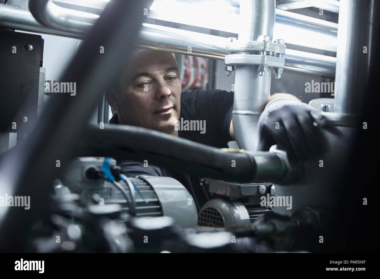 Worker checking hose line Stock Photo - Alamy