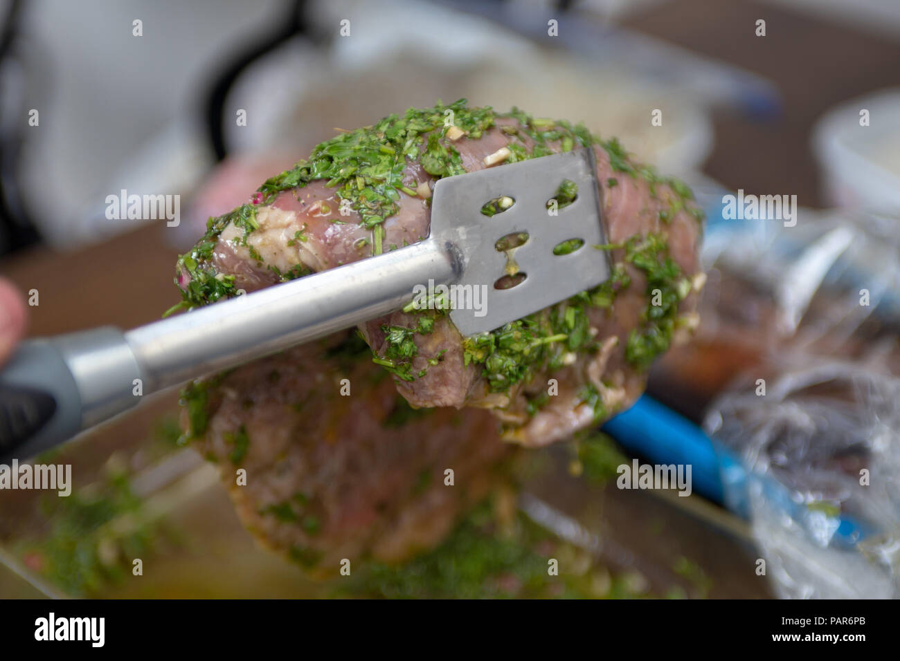 Grabbing marinated steak to be thrown on the grill Stock Photo - Alamy