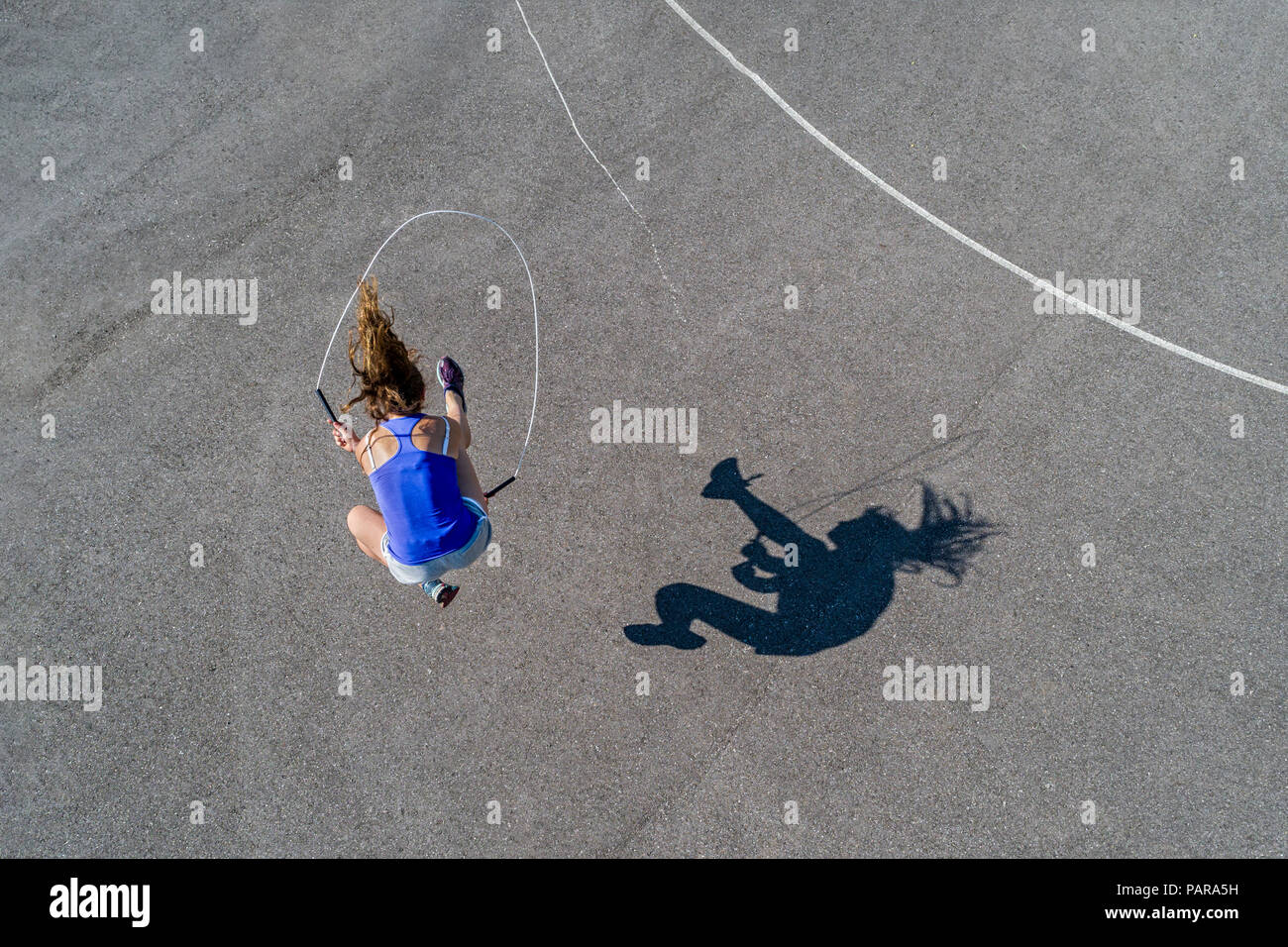Aerial view of young woman skipping rope, shadow Stock Photo - Alamy