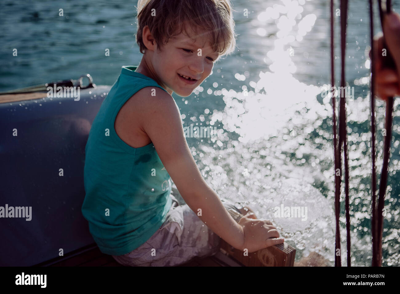 Smiling boy sitting on a sailing boat Stock Photo - Alamy