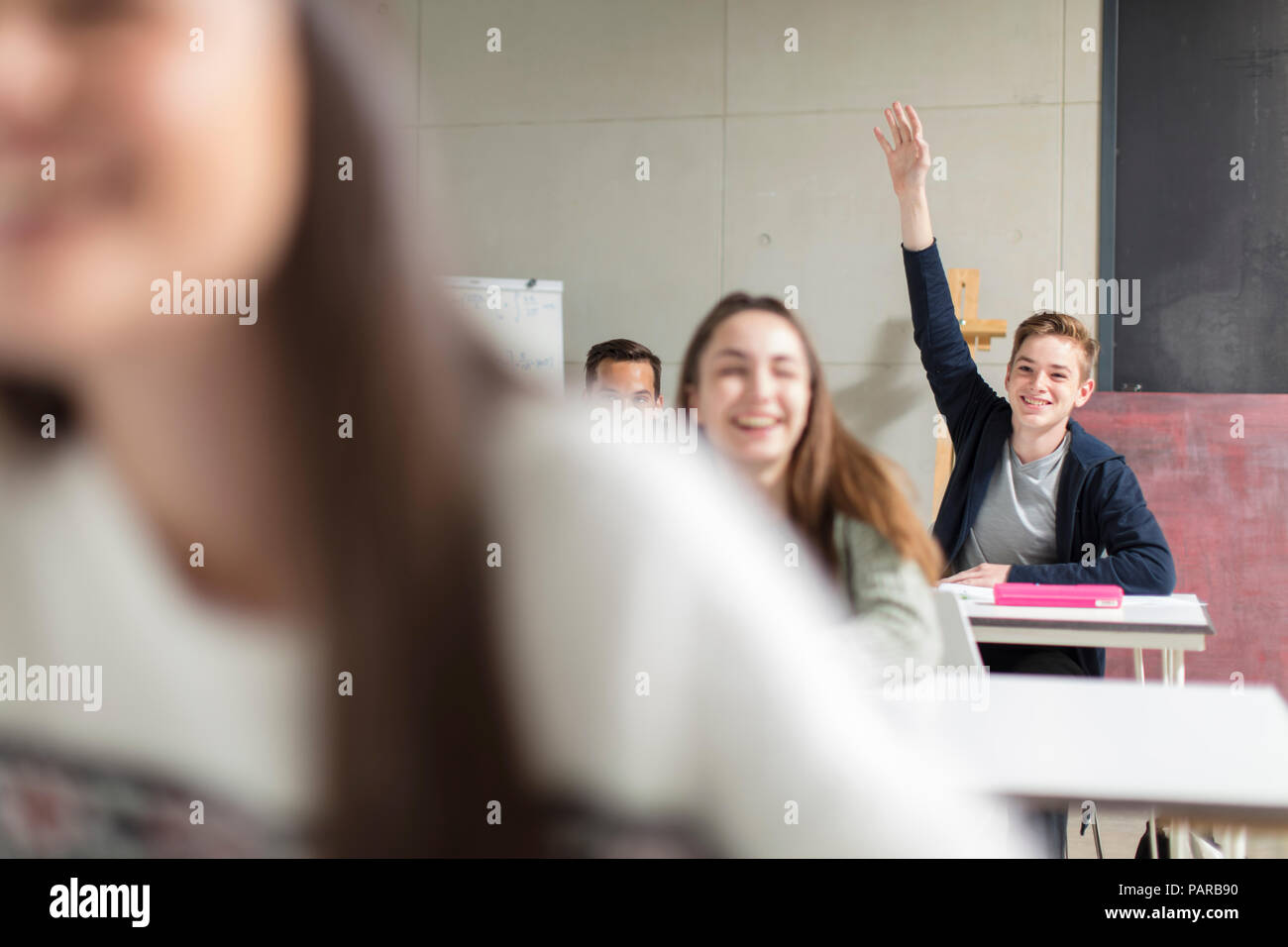 Boy raising hand in classroom hi-res stock photography and images - Alamy