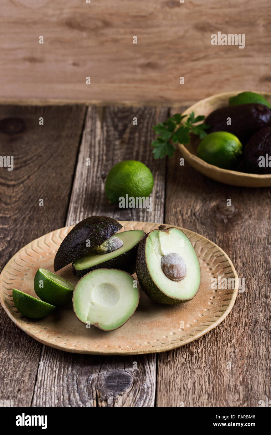 Fresh halved avocado on ceramic plate on rural wooden background Stock ...