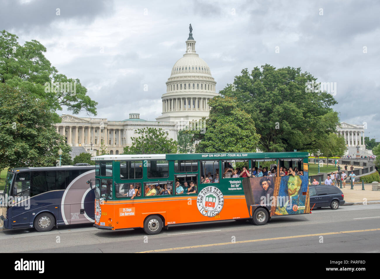 Tour buses pass the U.S. Capitol on a cloudy day Stock Photo - Alamy