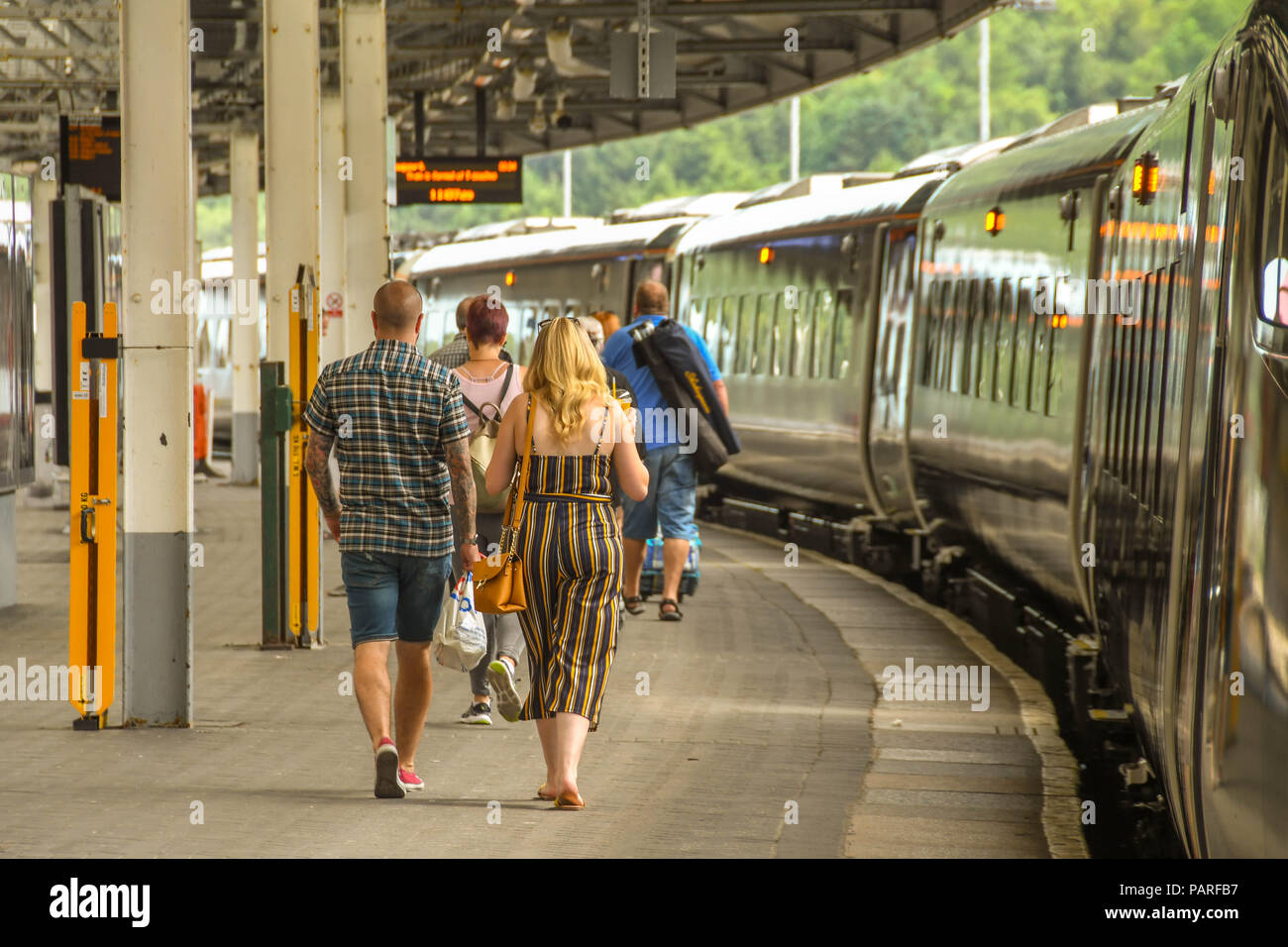 Passengers walking along a platform in Swansea station to board their ...