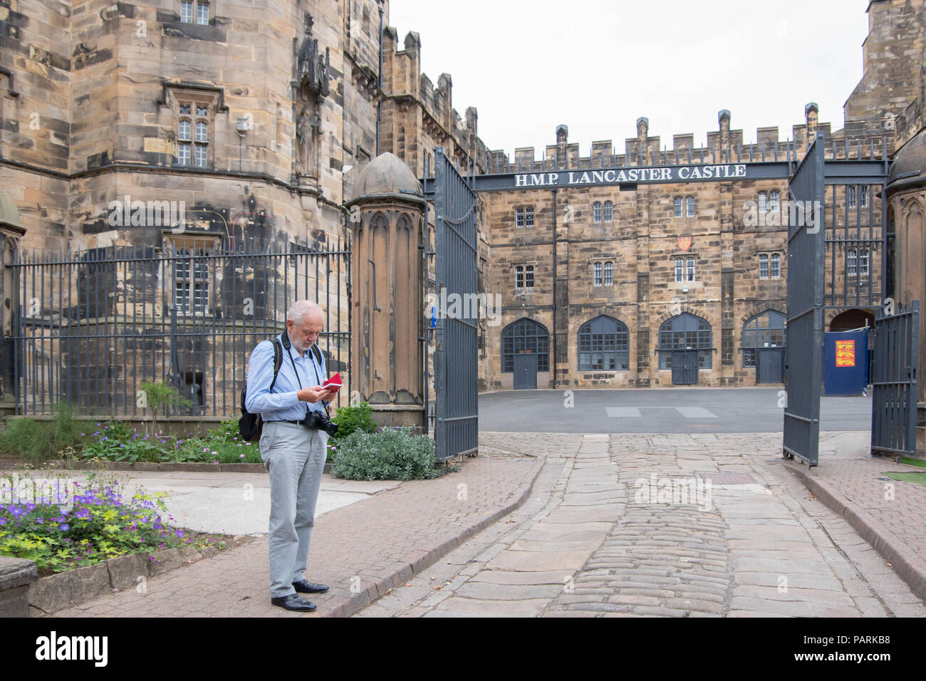 Elderly man with backpack looking at mobile phone with Lancaster HM ...