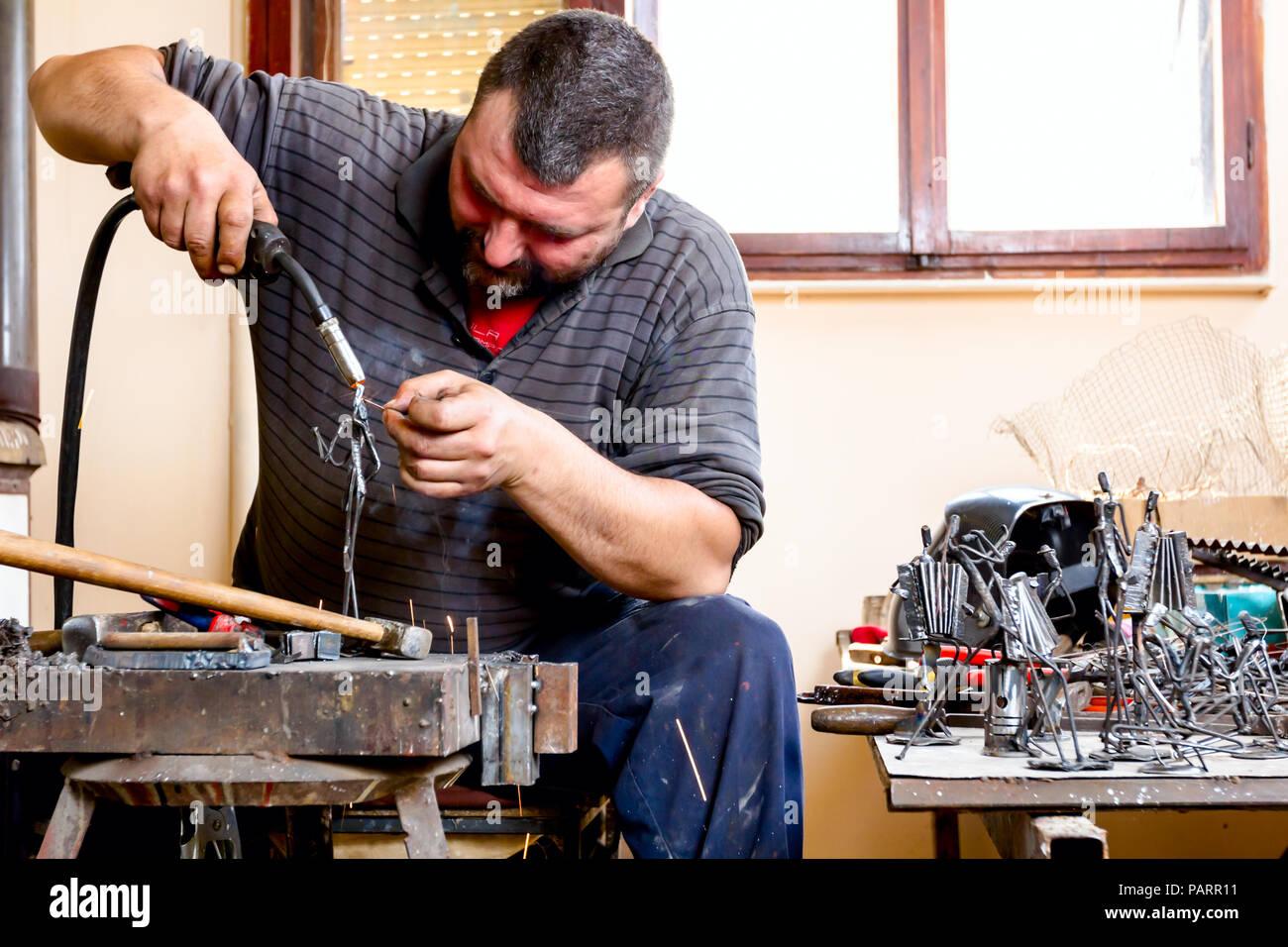 Sculptor is using arc welding to assembly metal sculpture without ...