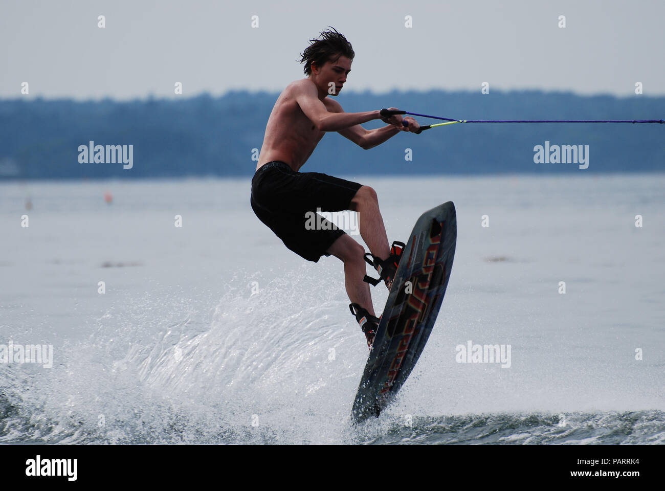 Wakeboarding young guy catching huge air over water Stock Photo - Alamy