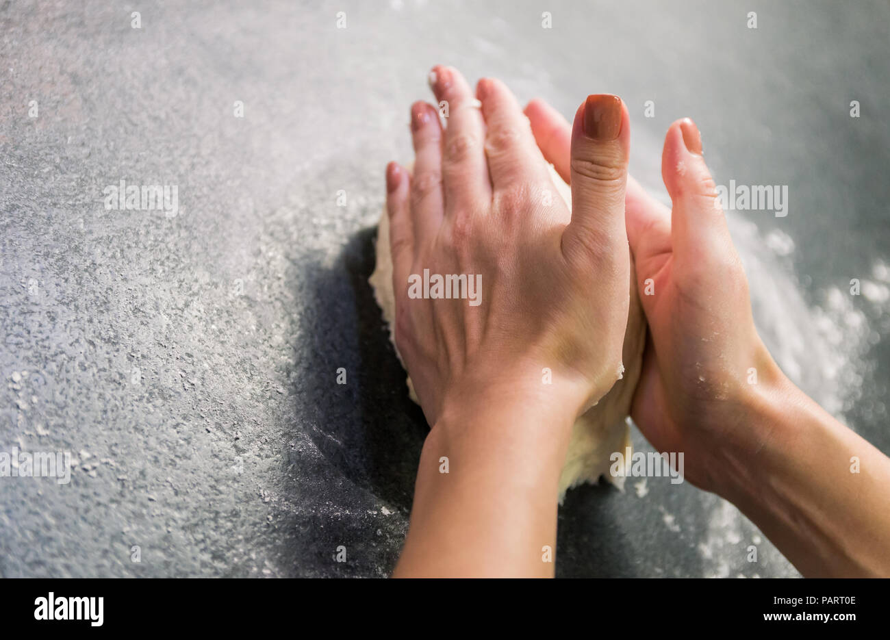 Woman preparing pizza dough on black granite table Stock Photo - Alamy